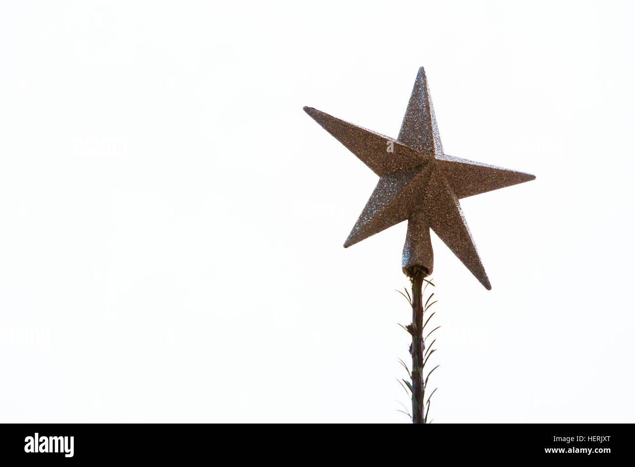 A single star mounted on the top of a christmas tree and set aginst a ...