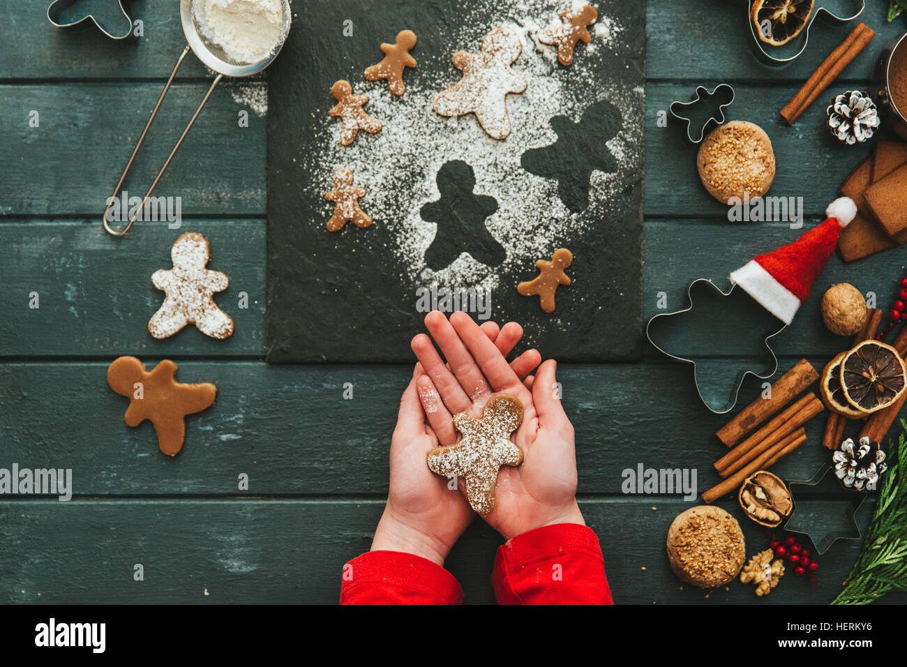 Girl holding gingerbread man with ingredients on table Stock Photo - Alamy