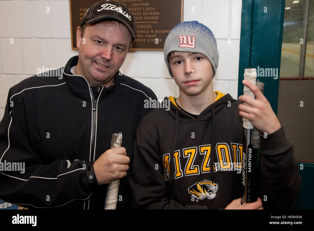 Father supporting son age 13 after a long school hockey game. St Paul ...