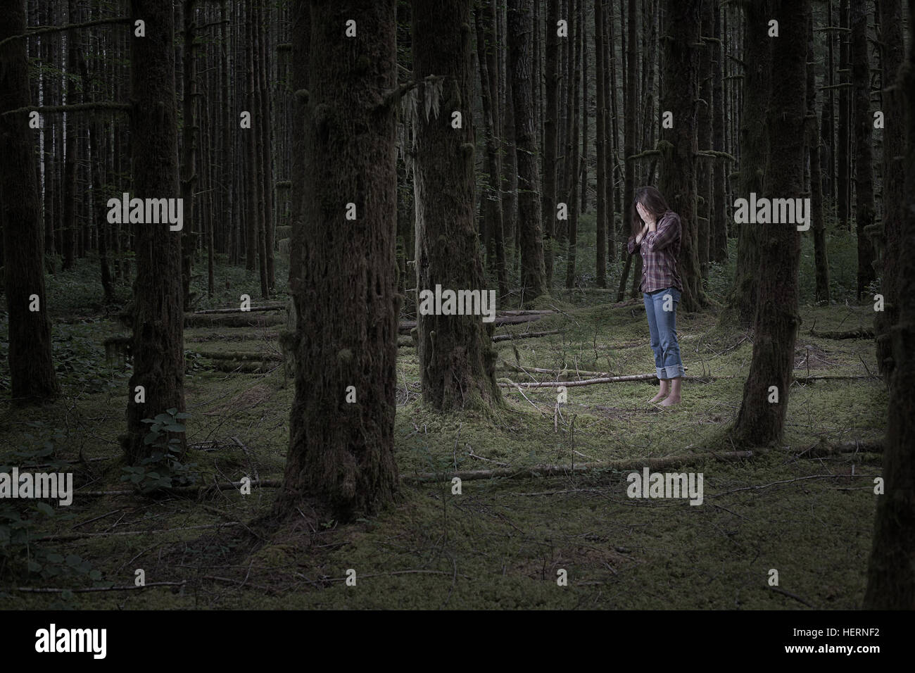 Woman standing alone in woods crying Stock Photo - Alamy