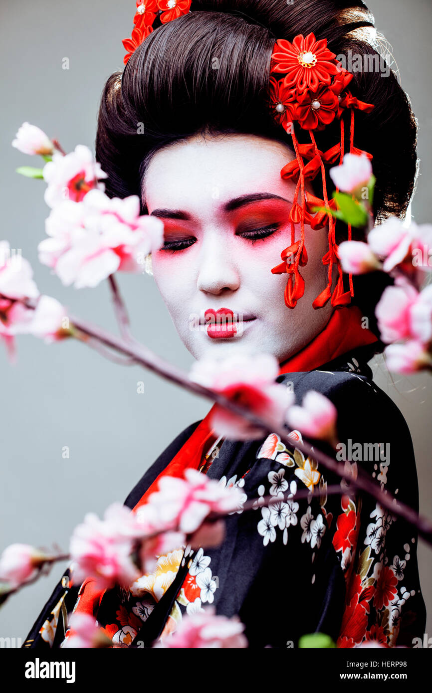 young pretty geisha in black kimono among sakura, asian ethno Stock ...
