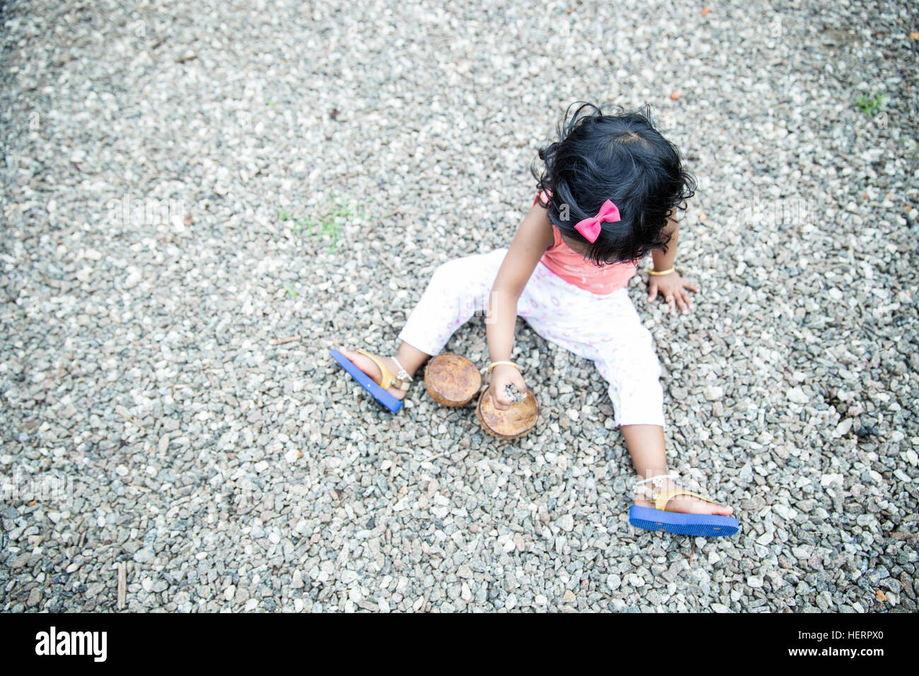 Toddler playing outdoors with coconut shell Stock Photo - Alamy