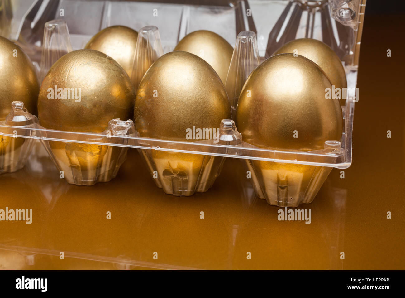 Golden eggs in a plastic box on golden background Stock Photo - Alamy
