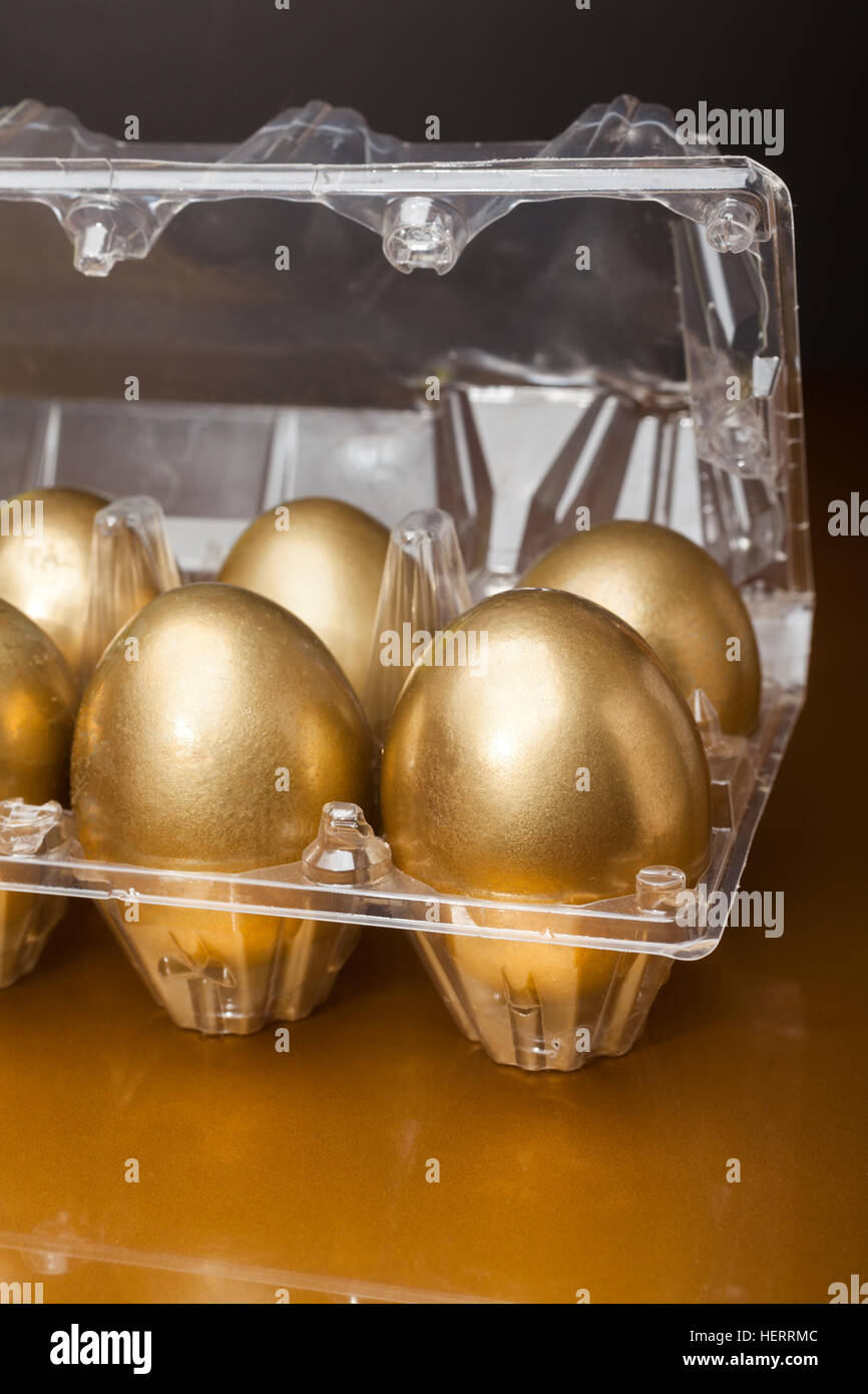 Golden eggs in a plastic box on golden background Stock Photo - Alamy