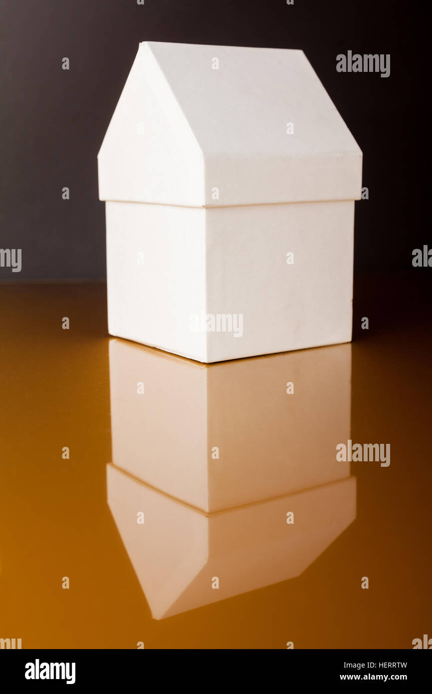 Cute white house, shaped box on golden background Stock Photo - Alamy