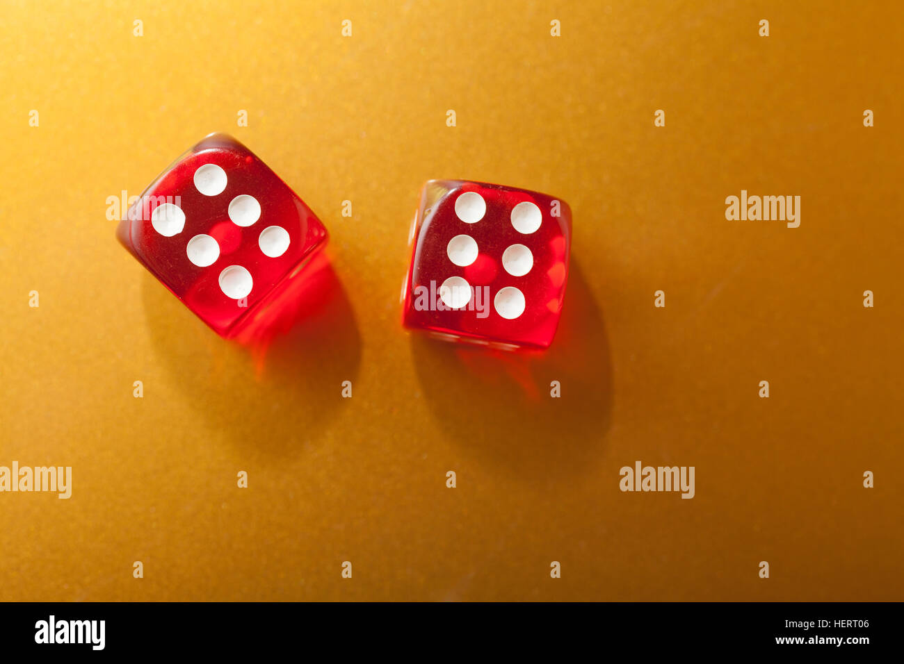 Two red dice on golden background with space for text Stock Photo - Alamy