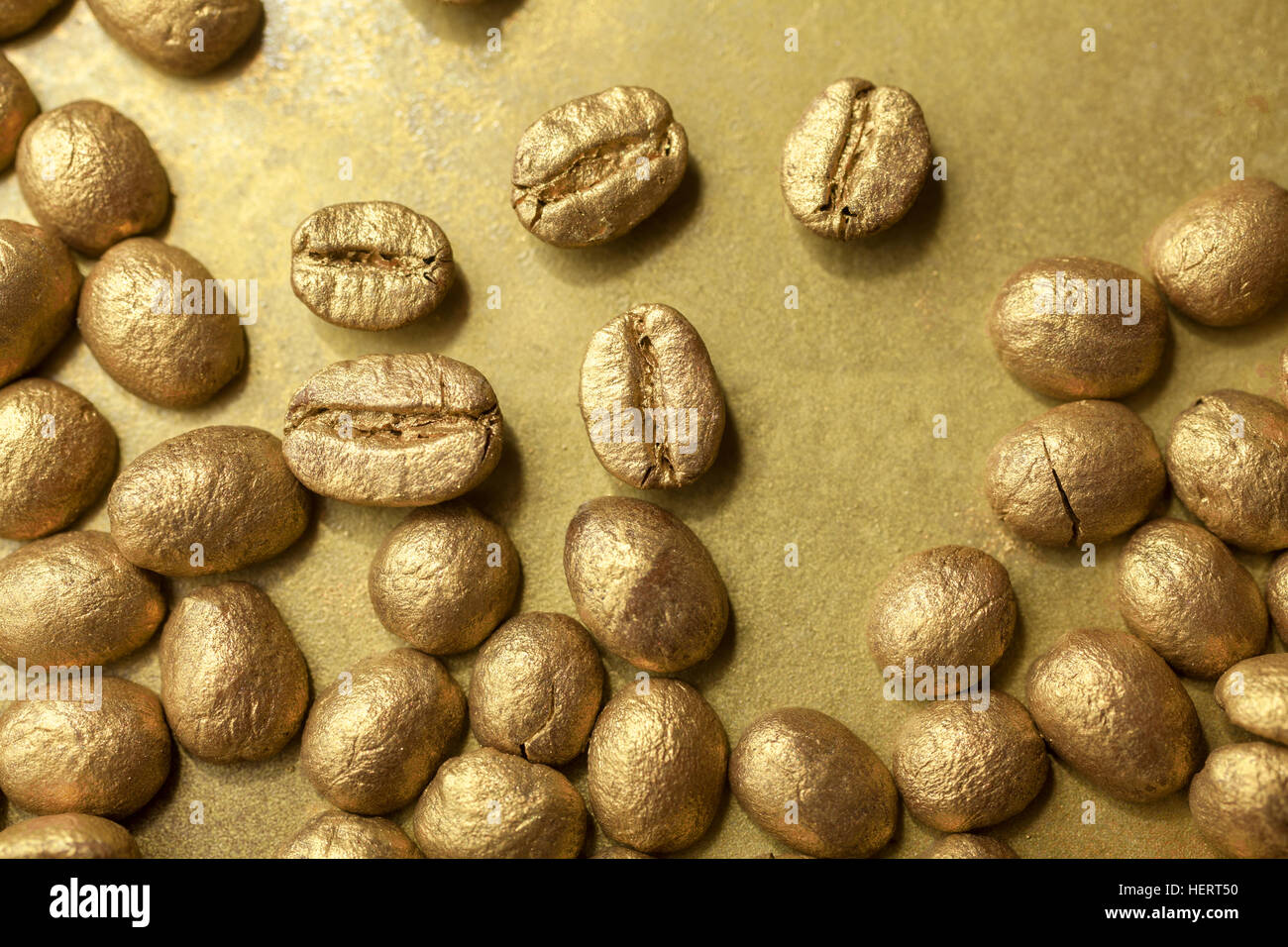 Golden beans of coffee on golden surface Stock Photo - Alamy
