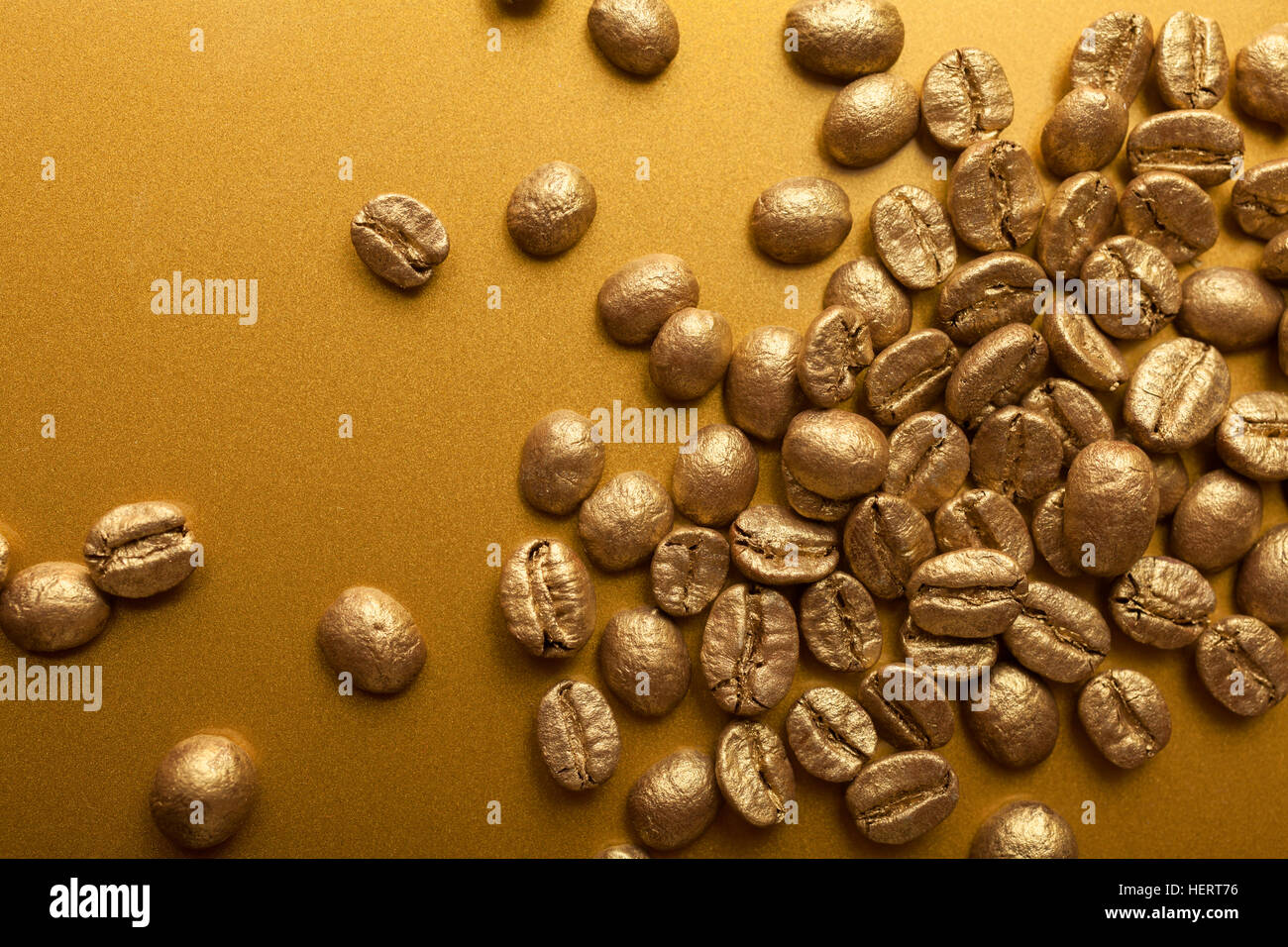 Golden beans of coffee on golden surface Stock Photo - Alamy