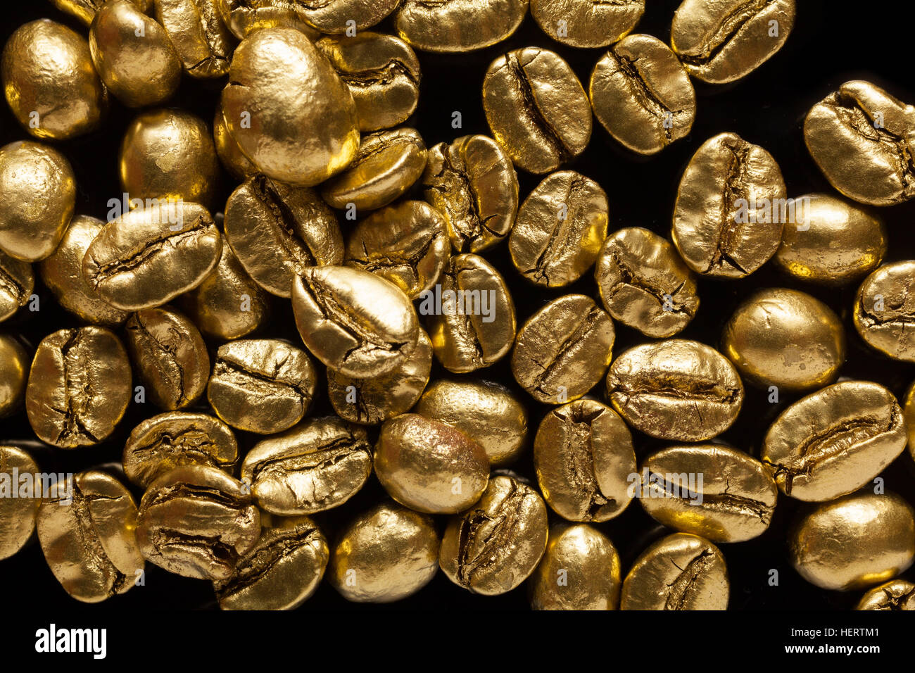 Golden cafe - coffee beans on black background Stock Photo - Alamy