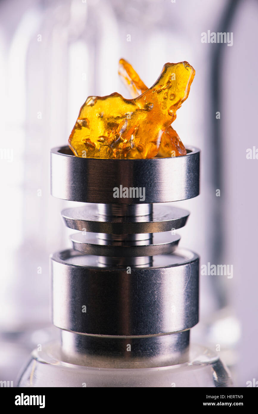 Piece of cannabis oil concentrate aka shatter over a titanium rig ...