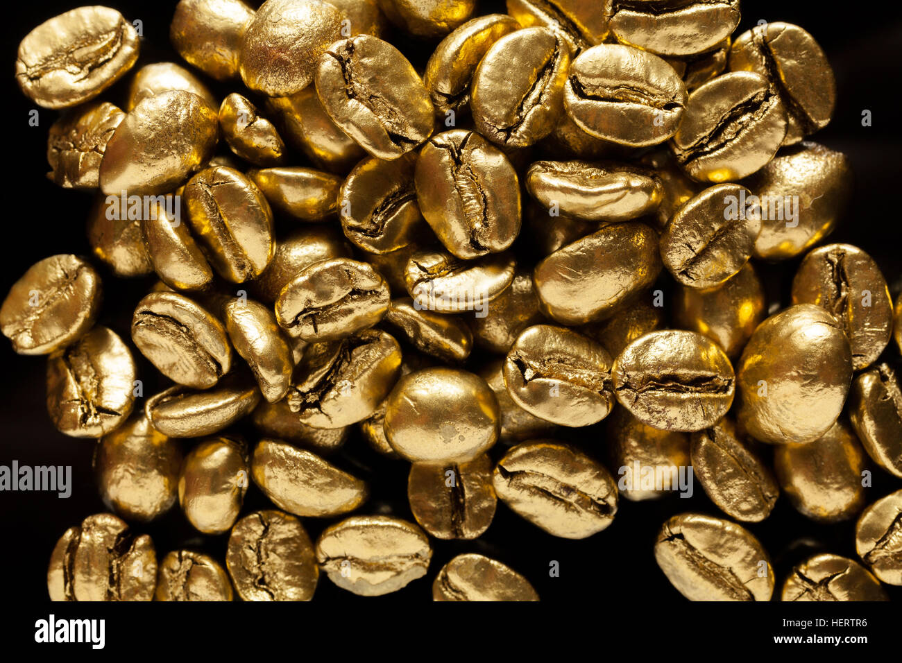 Golden cafe - coffee beans on black background Stock Photo - Alamy