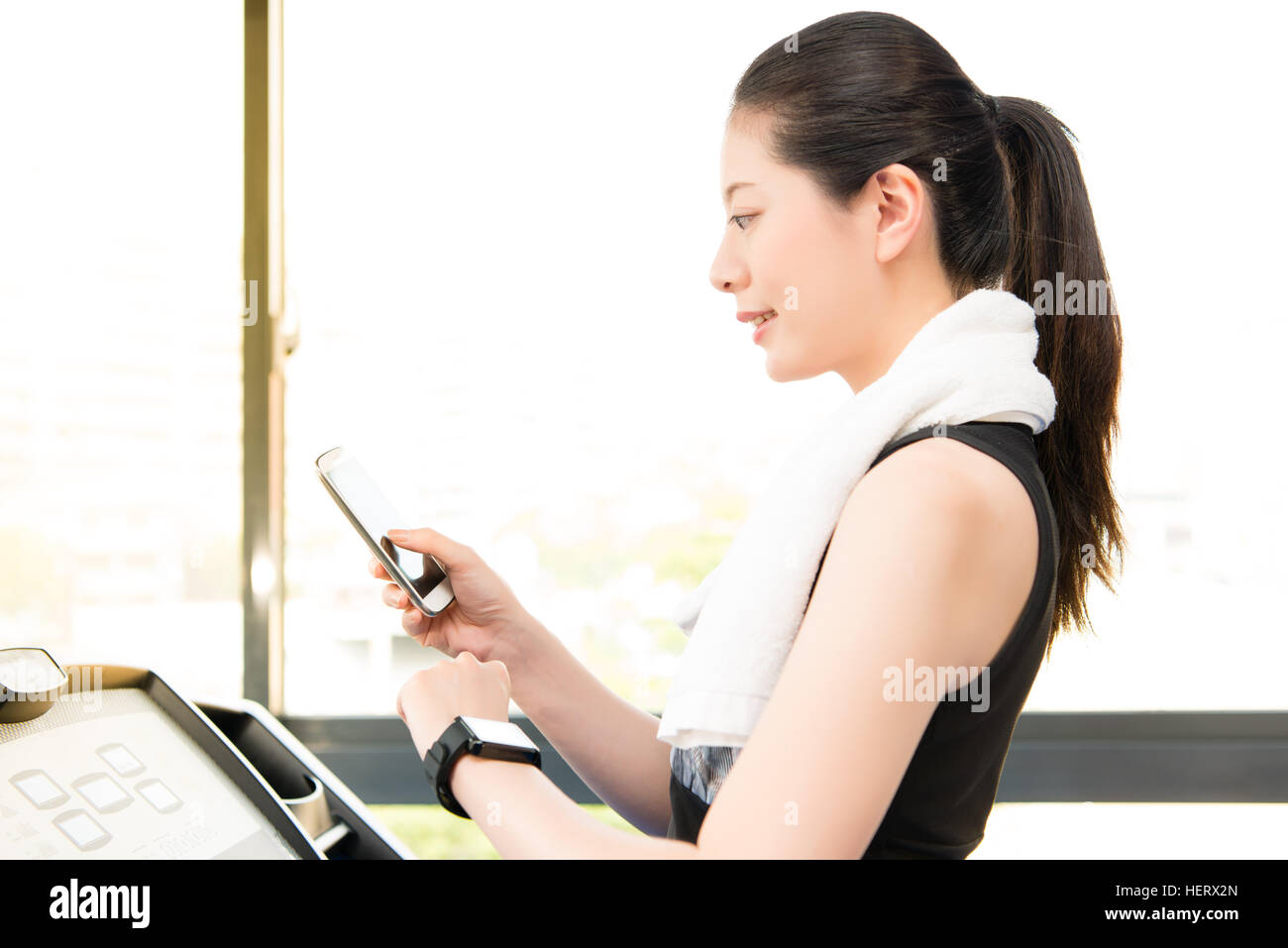 Beautiful asian woman running treadmill use smartwatch connect ...