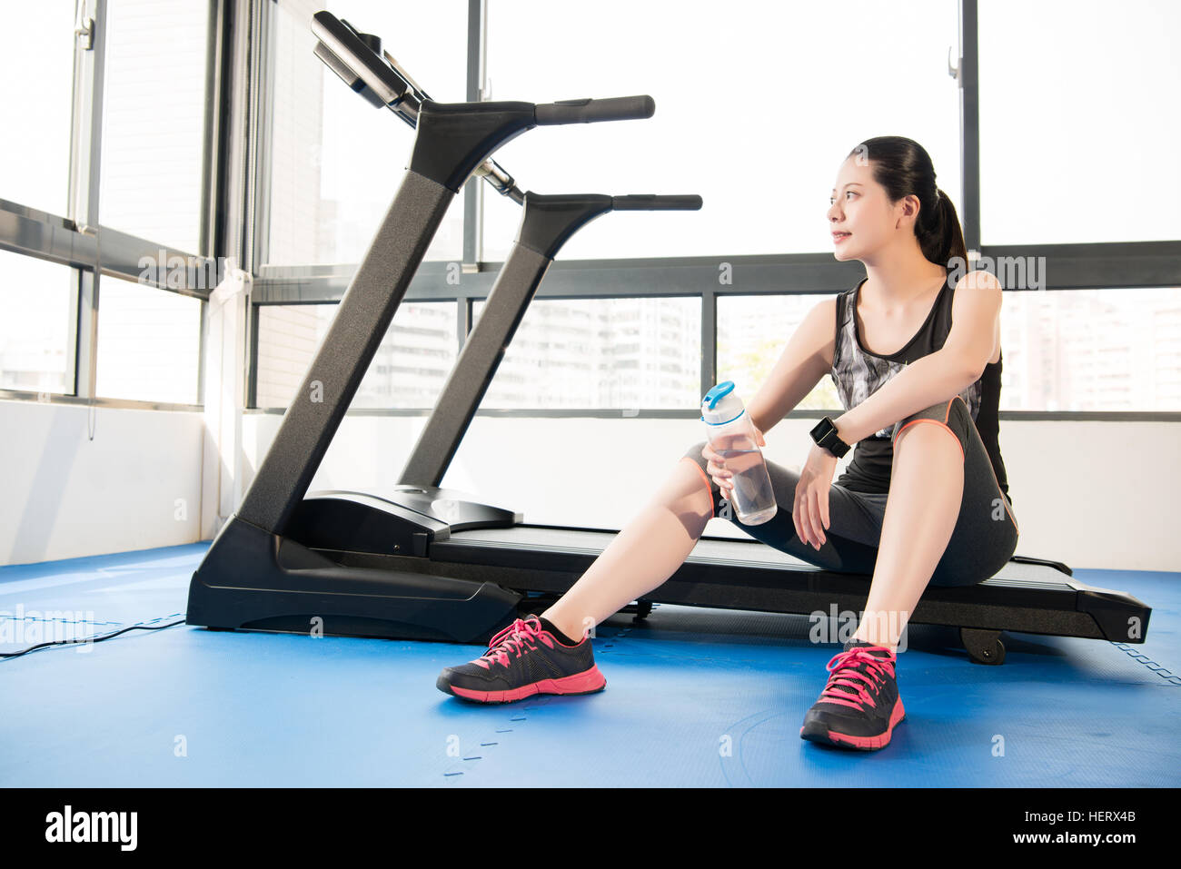 sport woman take rest on treadmill use smartwatch drinking water ...