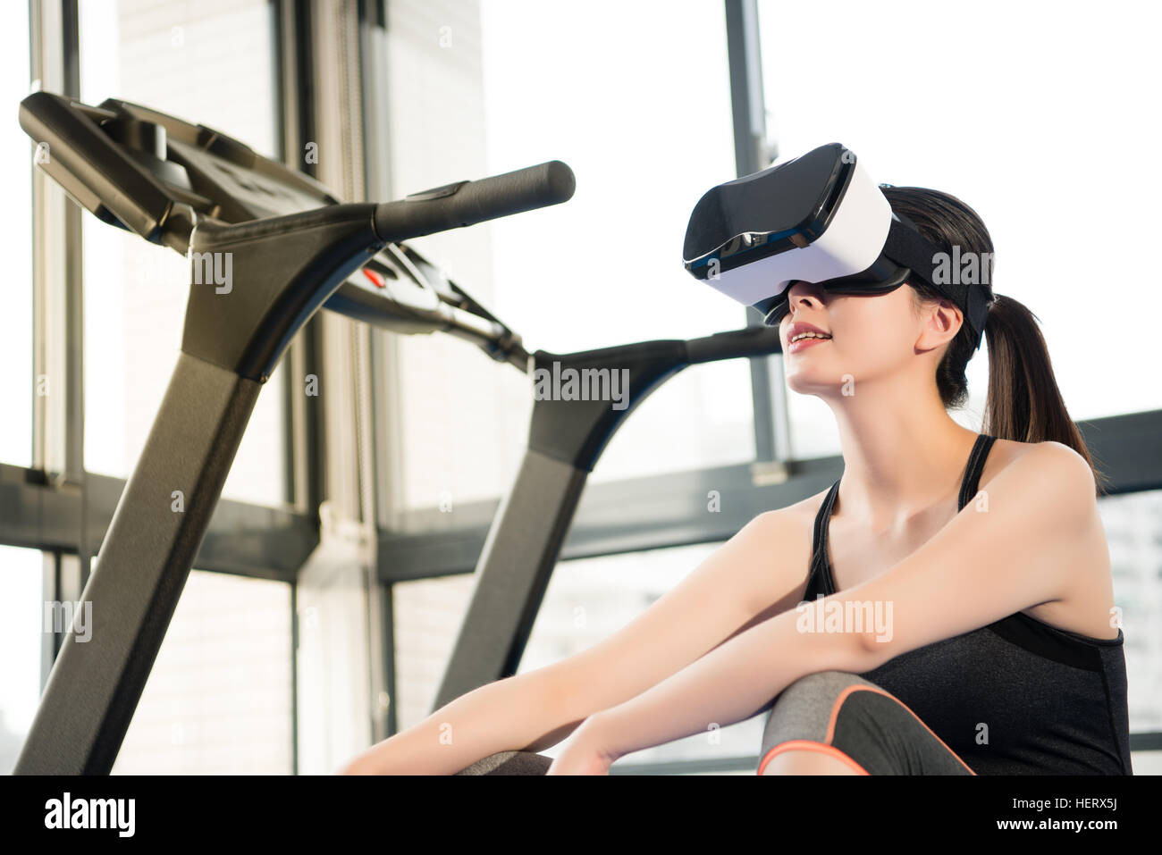 beauty asian woman rest on treadmill with virtual reality. VR headset ...