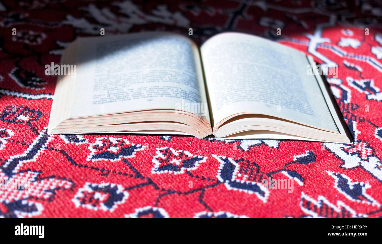 Open book on carpet at sunny rays Stock Photo - Alamy