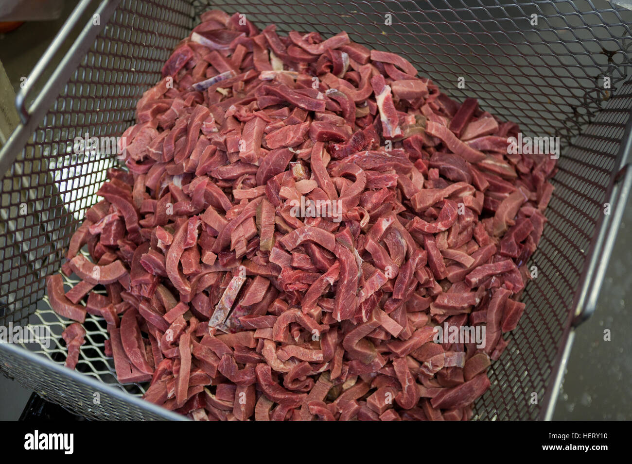 Raw meat pieces in a container at meat factory Stock Photo - Alamy