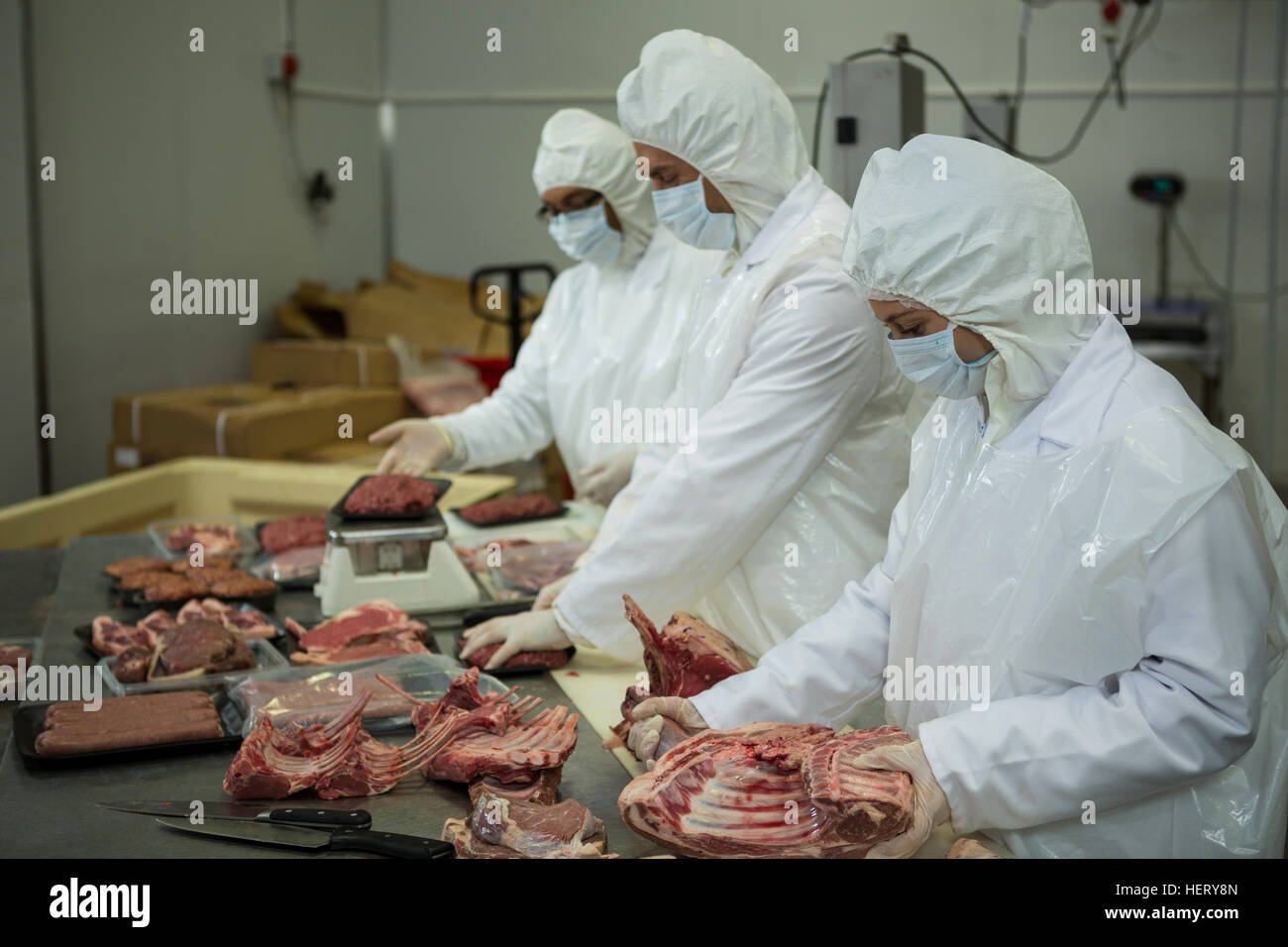 Butchers cleaning raw meat at meat factory Stock Photo - Alamy