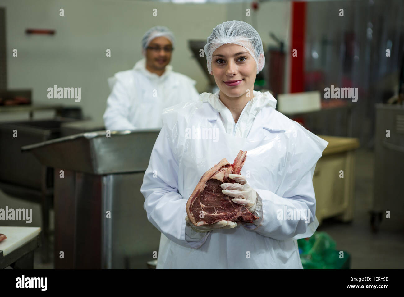 Portrait of female butcher holding meat at meat factory Stock Photo - Alamy