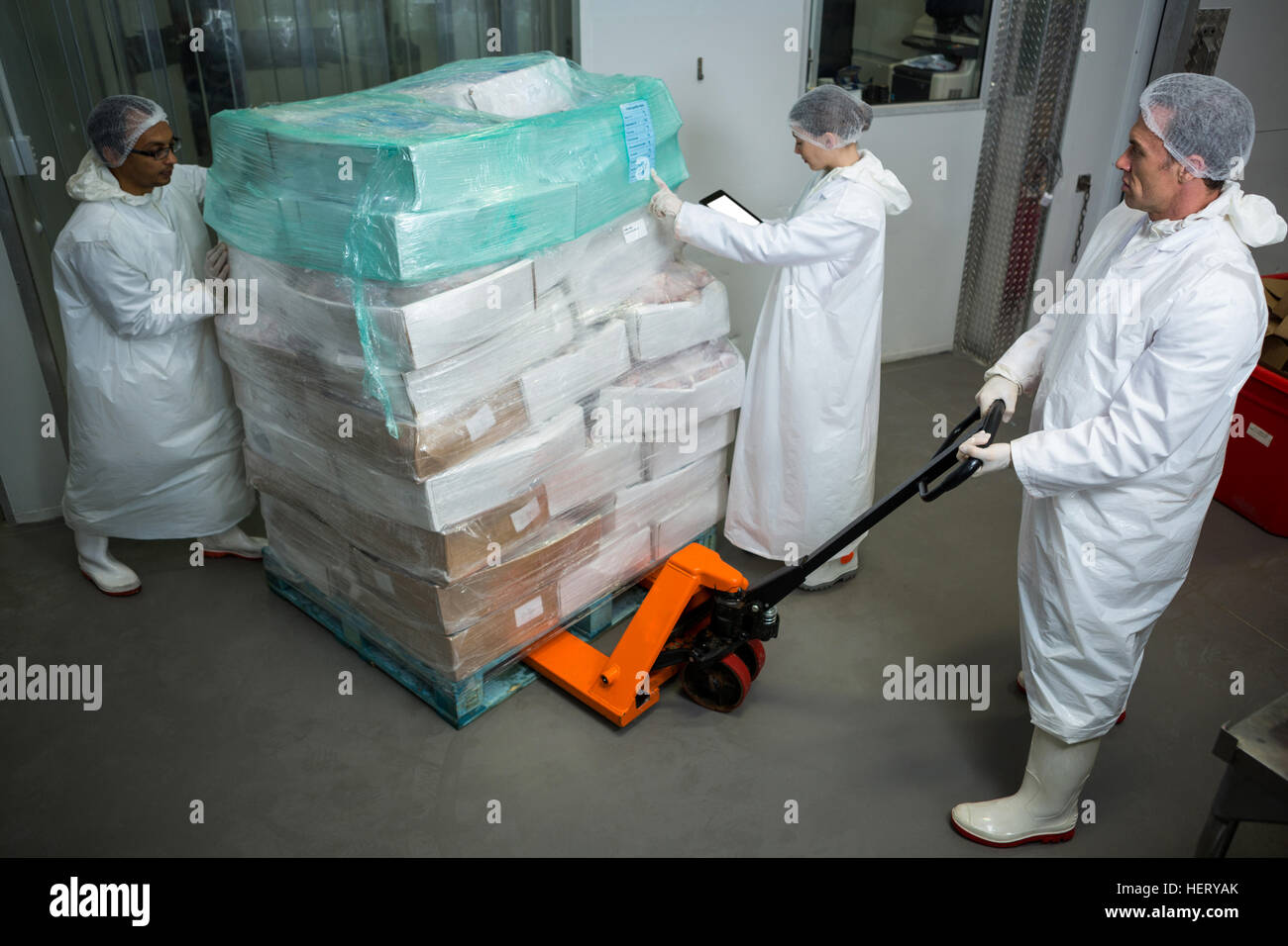 Factory staff moving boxes using a forklift at meat factory Stock Photo ...