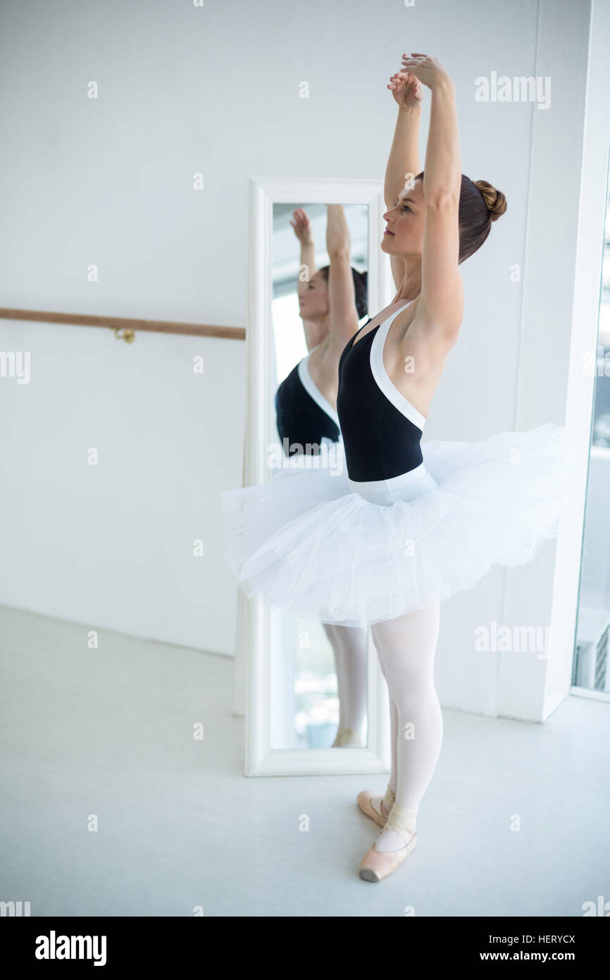 Ballerina practicing ballet dance in front of mirror in the studio ...