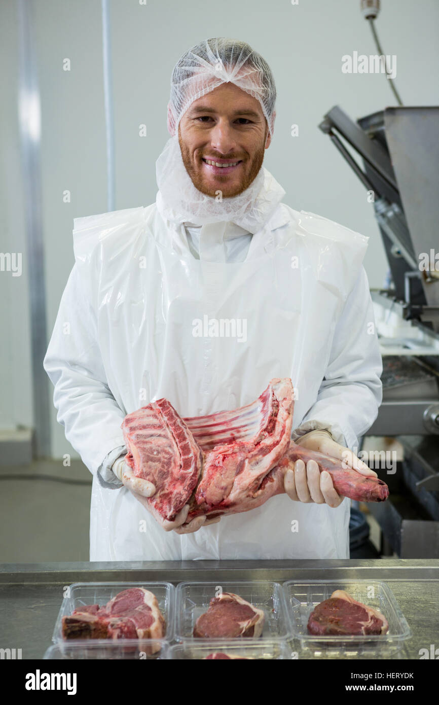 Portrait of butcher holding raw meat at meat factory Stock Photo - Alamy