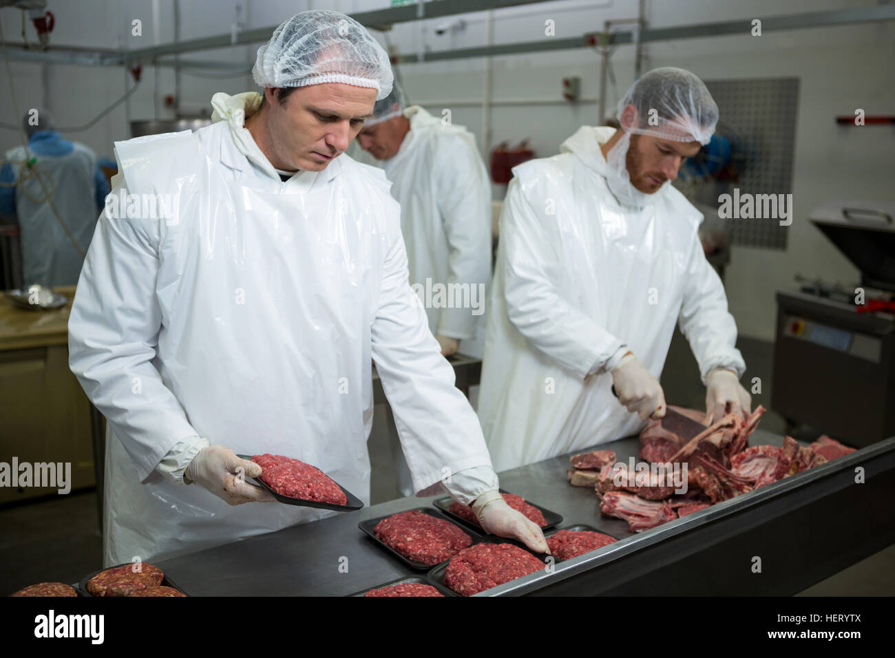 Butchers working together at meat factory Stock Photo - Alamy