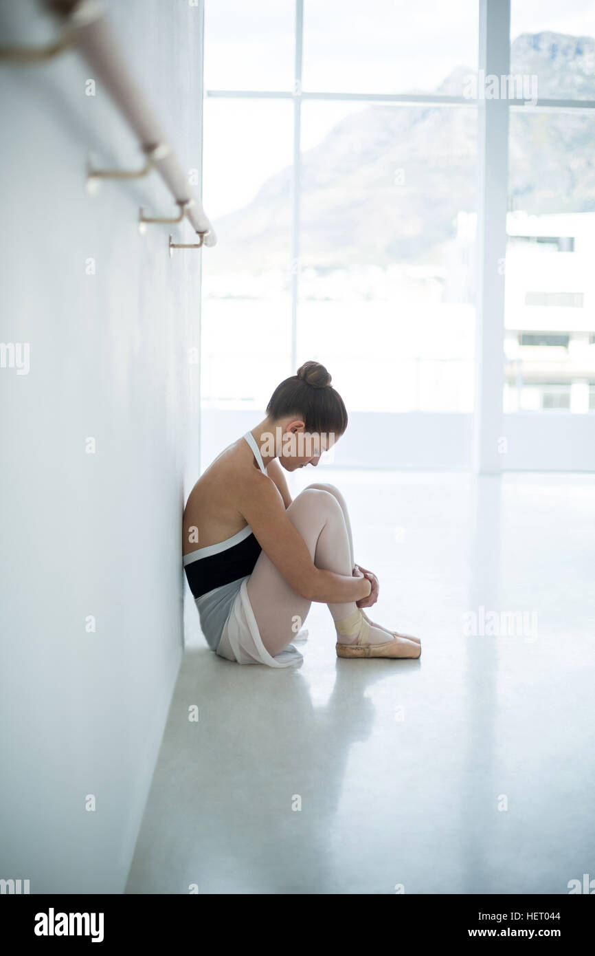 Sad ballerina sitting on floor in the ballet studio Stock Photo - Alamy