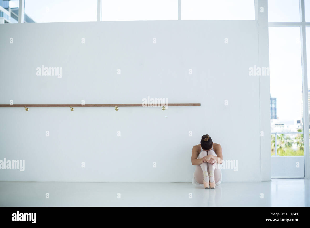 Sad ballerina sitting on floor in the ballet studio Stock Photo - Alamy