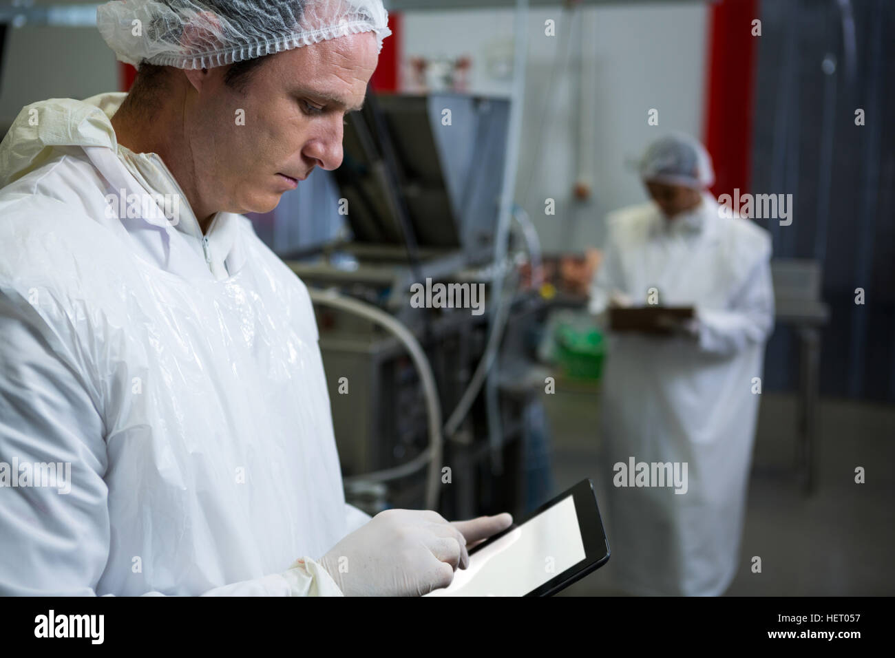 Male butcher using digital tablet at meat factory Stock Photo - Alamy