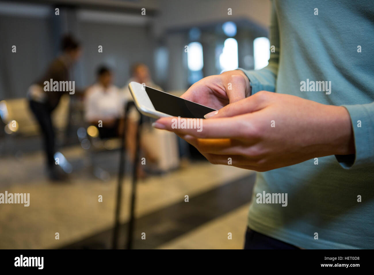 Mid-section of woman using mobile phone in airport terminal Stock Photo ...