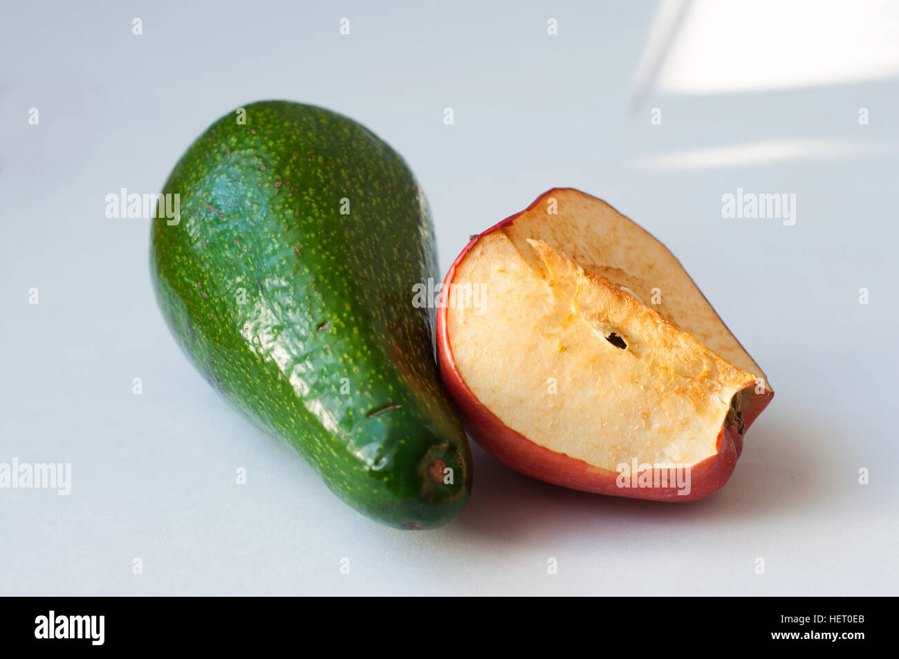 An avocado and a piece of apple on a white background Stock Photo - Alamy