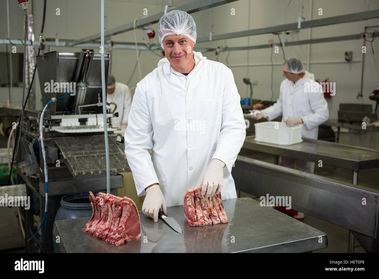 Portrait of butchers cutting meat at meat factory Stock Photo - Alamy