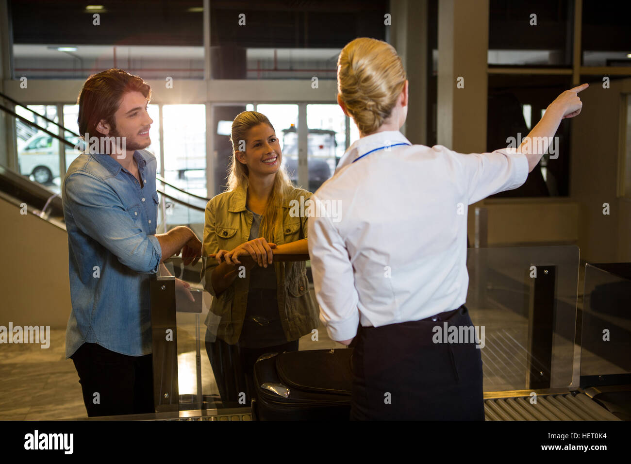 Female staff guiding passengers in the airport terminal Stock Photo - Alamy