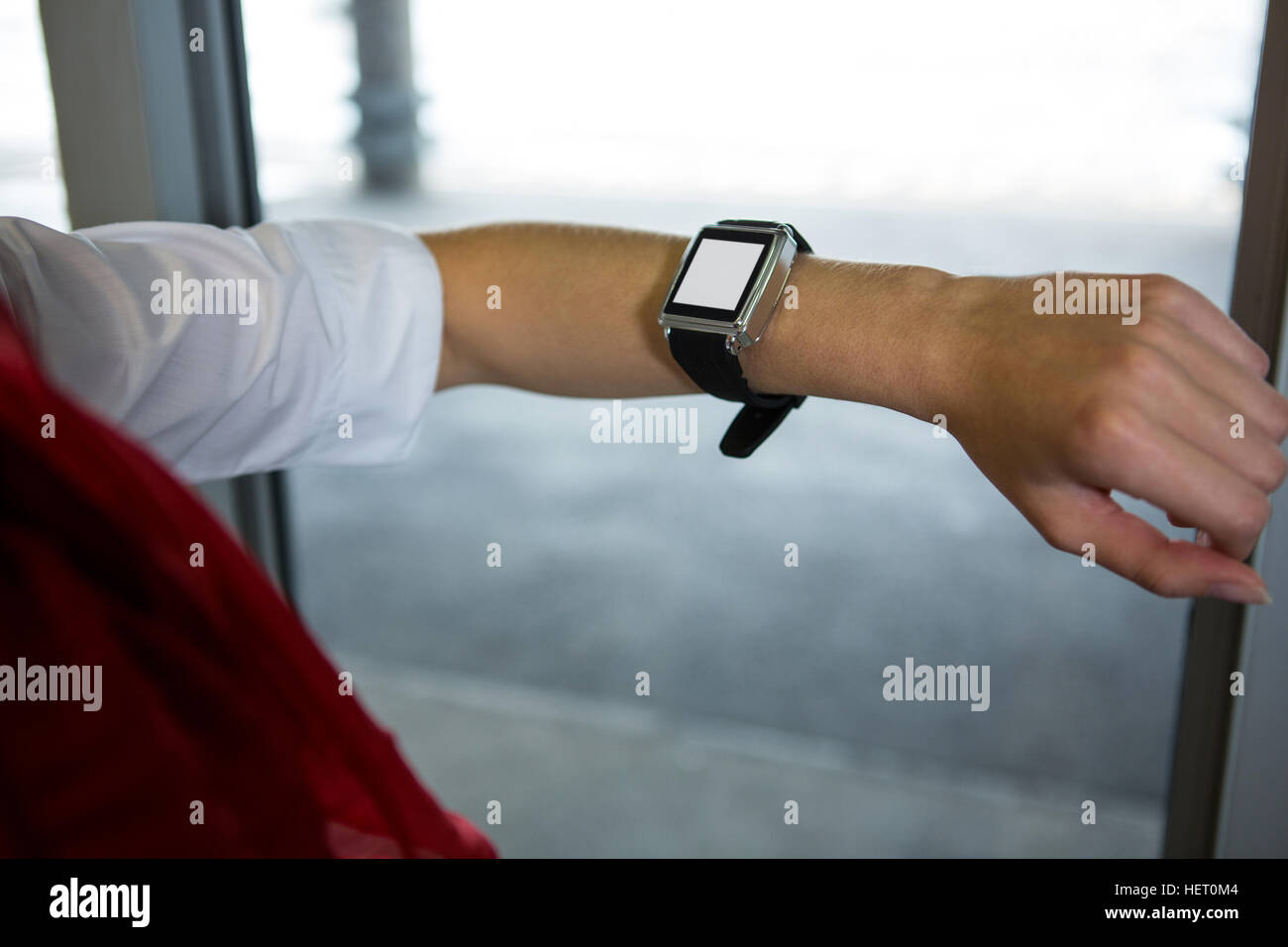 Mid-section of air hostess checking time on her smartwatch in the ...