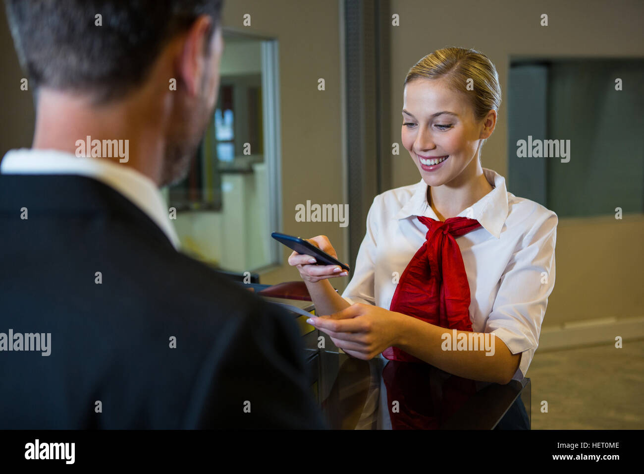 Female scanning the boarding pass with mobile phone at airport terminal ...