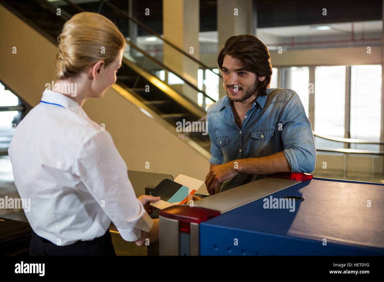 Passenger Having A Conversation With Female Staff In The Airport