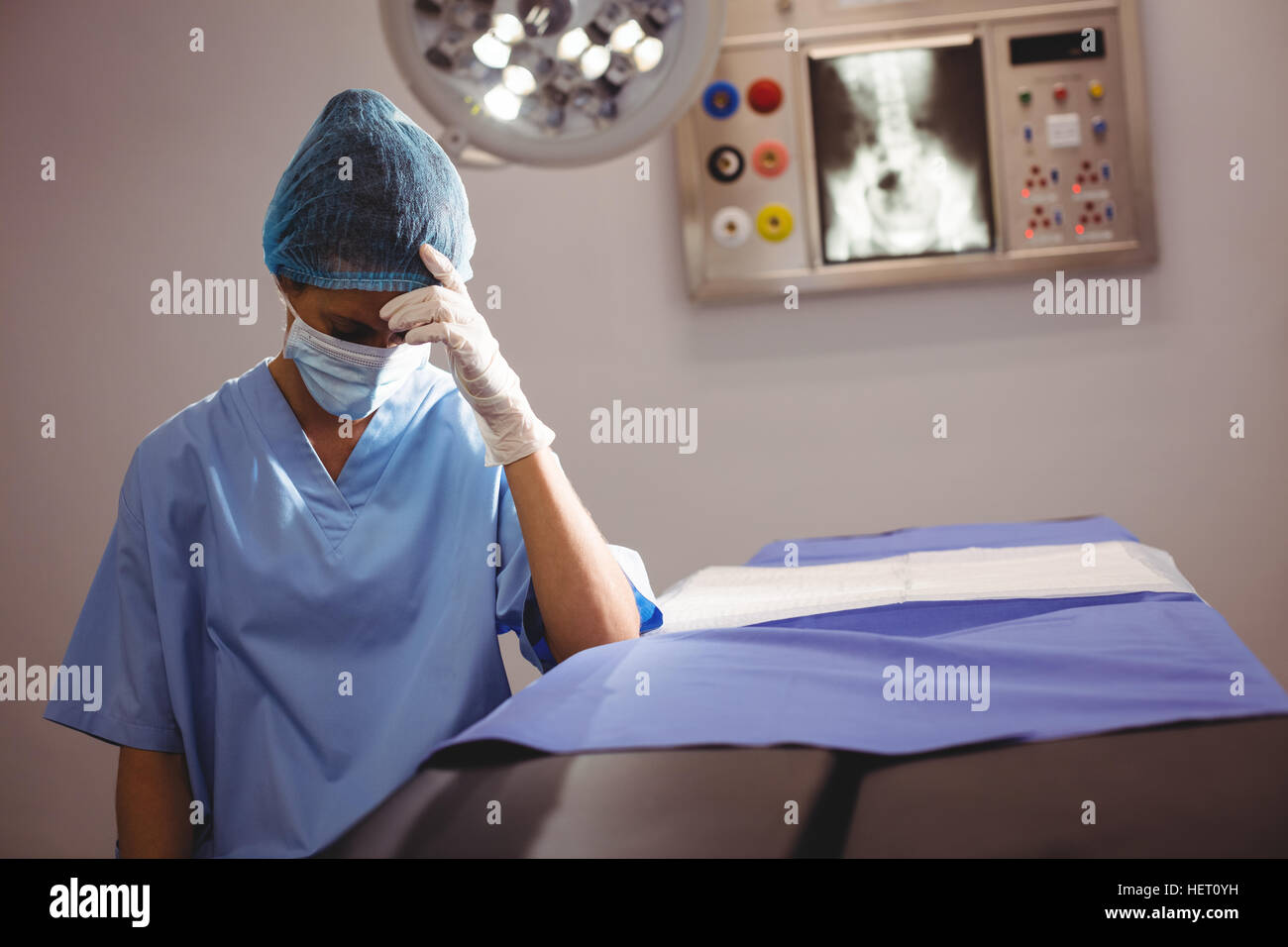 Sad female nurse sitting in operation theater at hospital Stock Photo ...