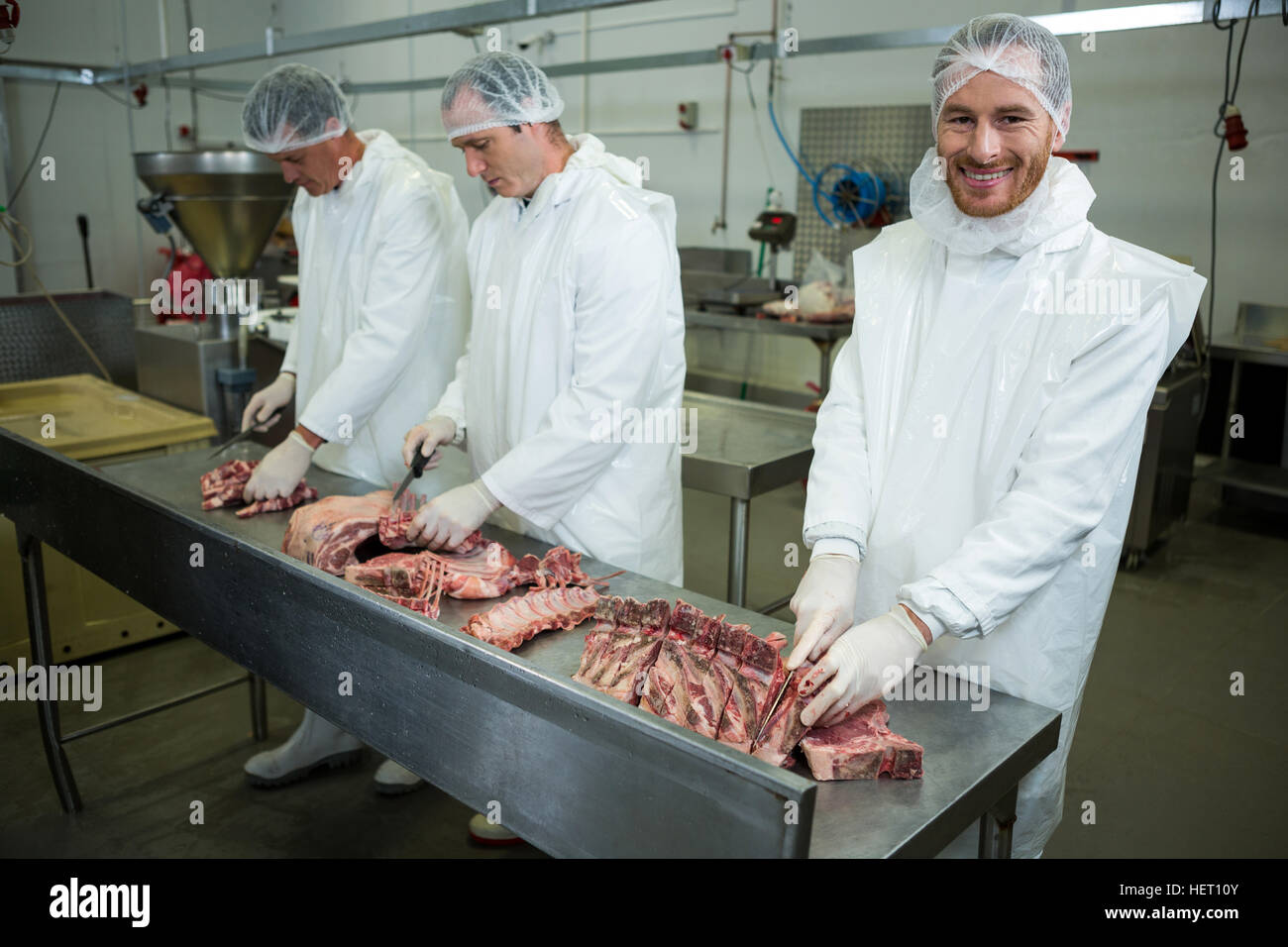 Butchers cutting meat at meat factory Stock Photo - Alamy