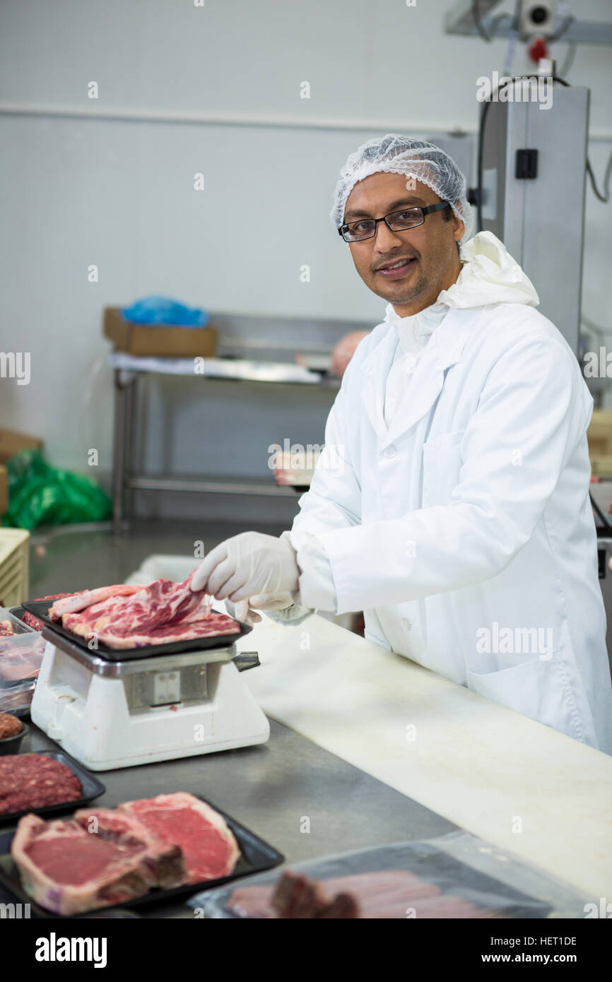 Butcher weighing meat on scale at meat factory Stock Photo - Alamy