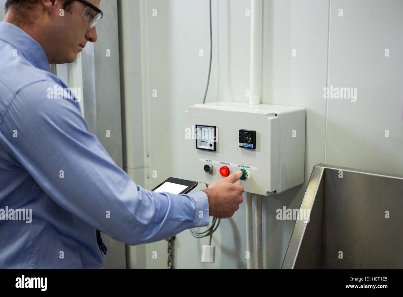 Technician operating machine at meat factory Stock Photo - Alamy
