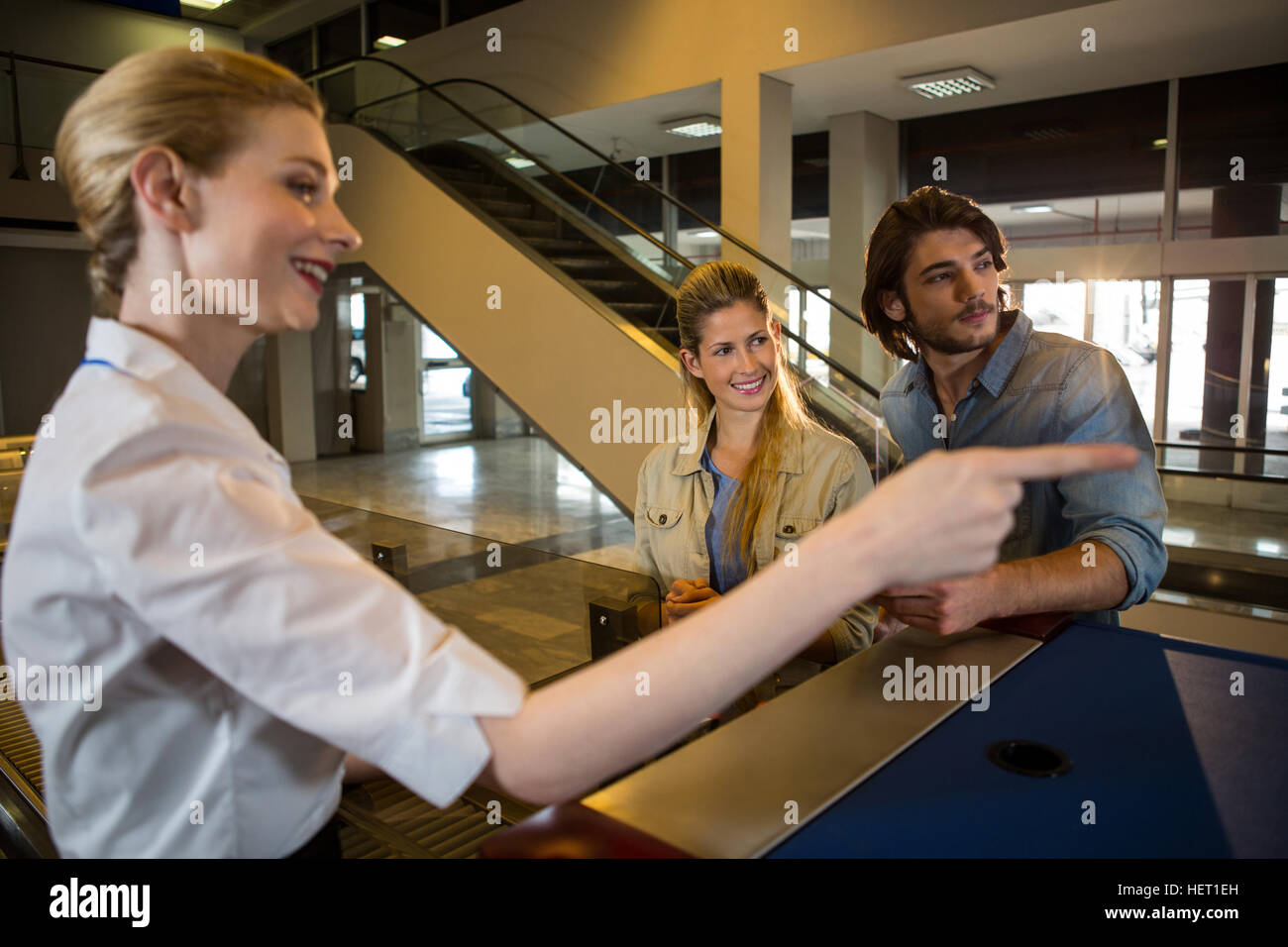 Female staff guiding passengers in the airport terminal Stock Photo - Alamy