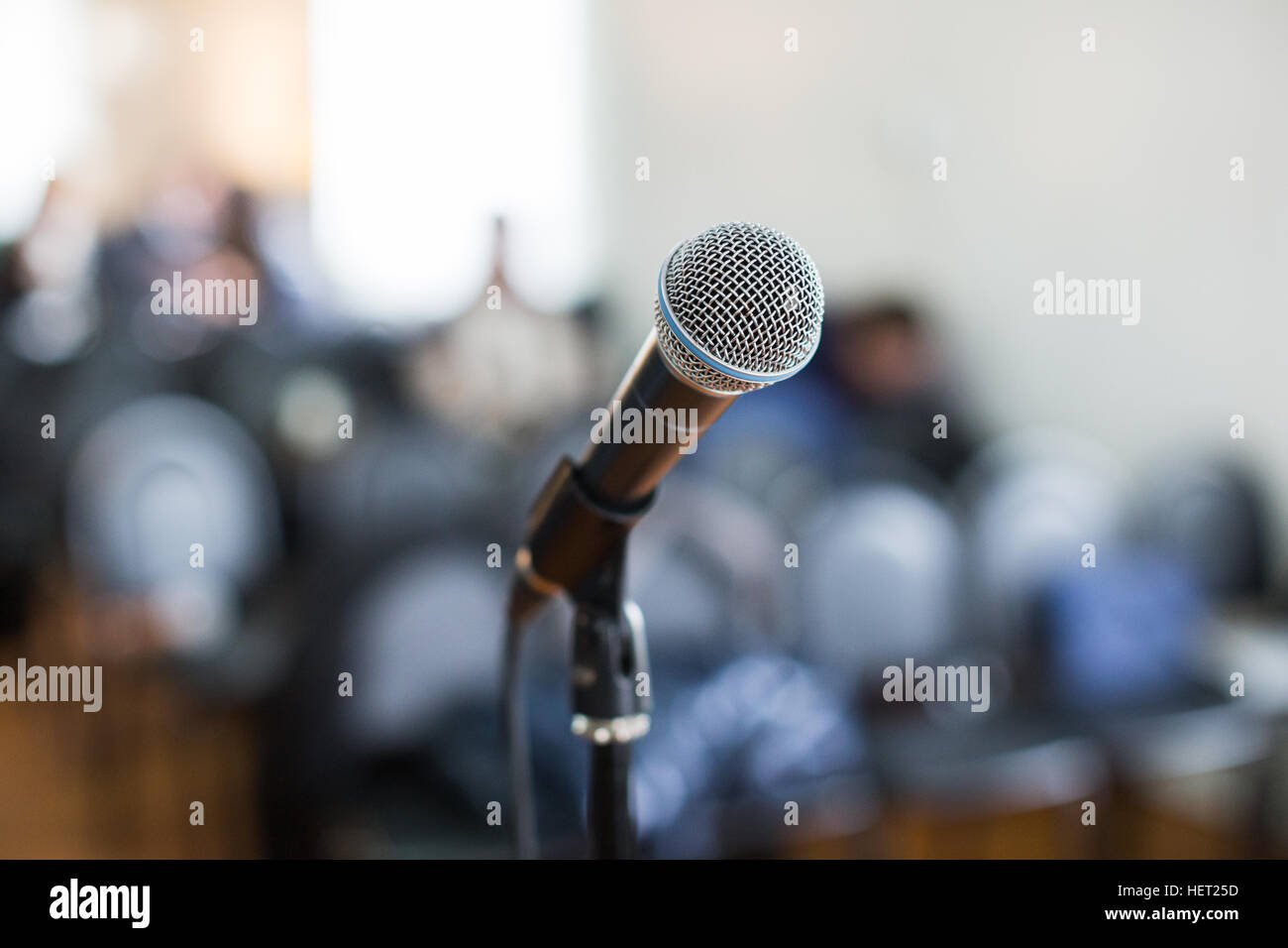 Vocal Microphone in focus against blurred audience at the conference or ...