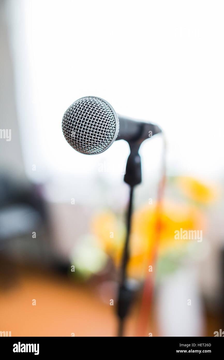 Vocal Microphone in focus against blurred audience at the conference or ...