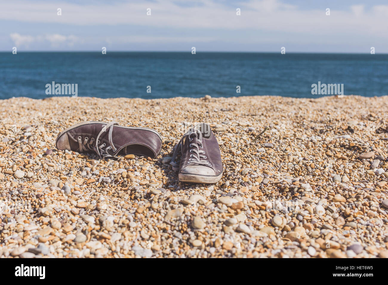 A pair of shoes on a pebble beach in summer Stock Photo - Alamy