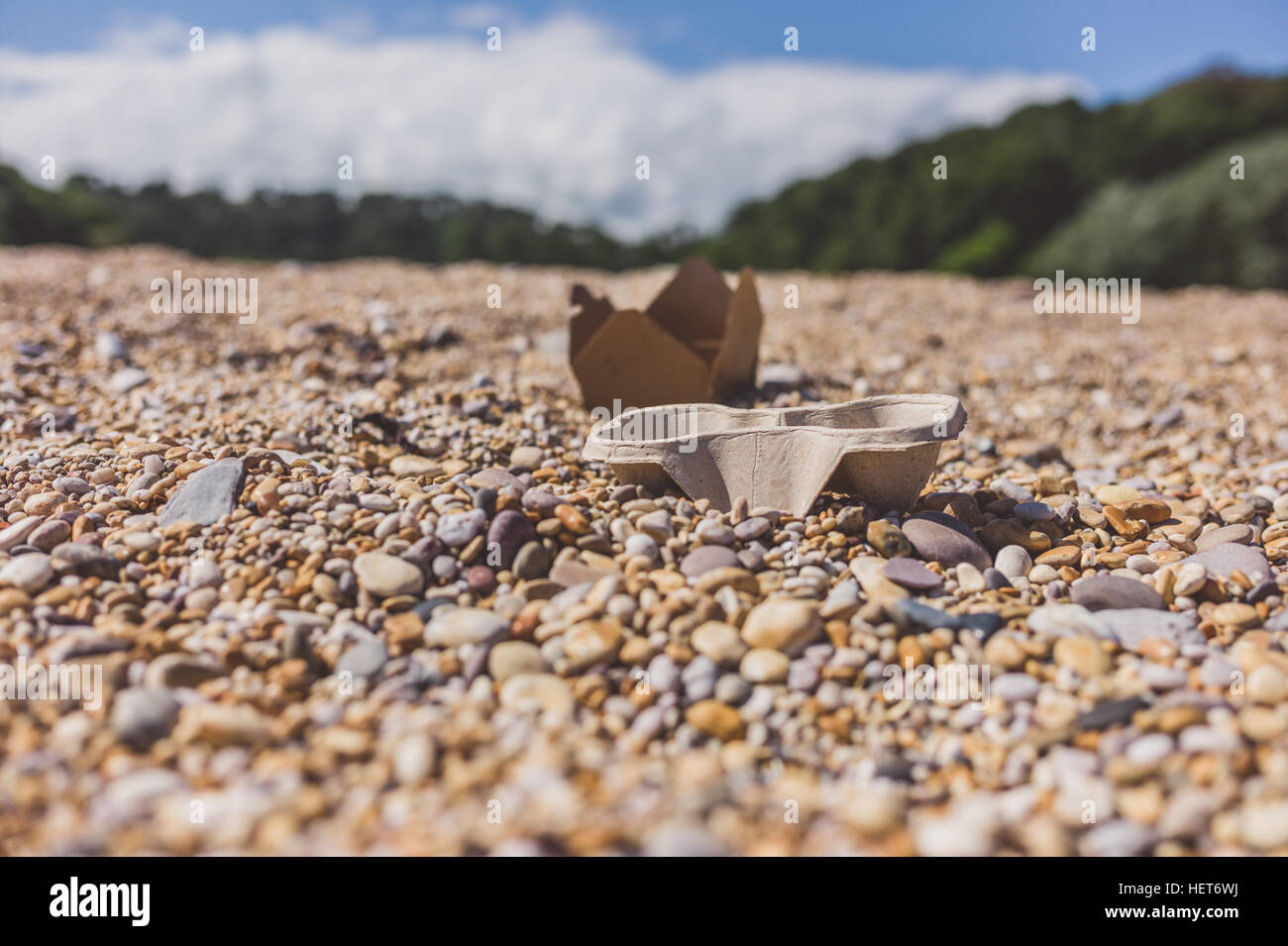 Empty food wrappers abandoned on a pebble beach Stock Photo - Alamy
