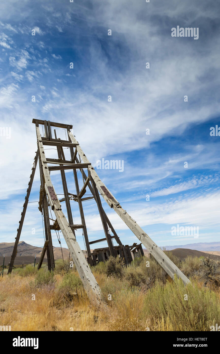 Old mining head frame in the Nevada Desert under blue sky with clouds ...