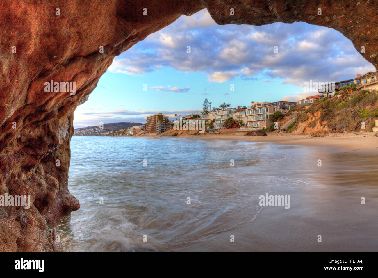 Sunset hits homes along Pearl Street Beach through a rock keyhole in ...