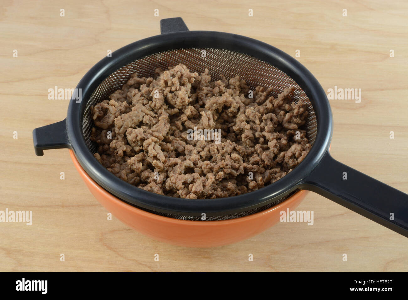Draining Fat And Grease From Cooked Hamburger Meat In Strainer In Bowl draining-fat-and-grease-from-cooked-hamburger-meat-in-strainer-in-bowl