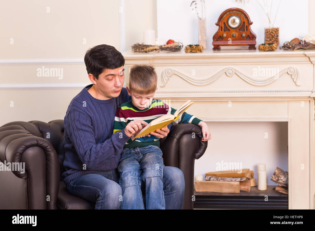 kid boy and his father read a book at home Stock Photo - Alamy