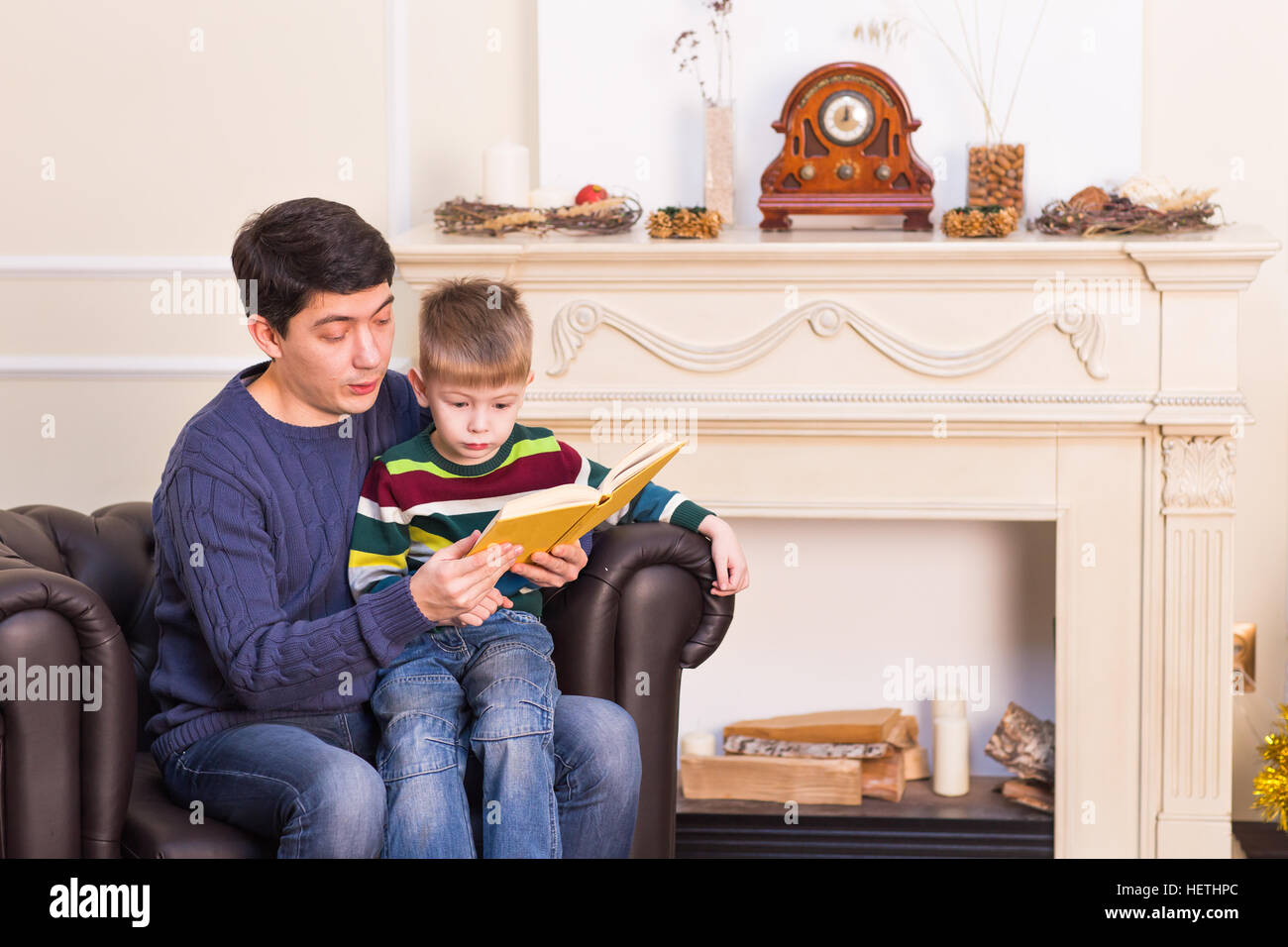 Father and son reading story book together Stock Photo - Alamy